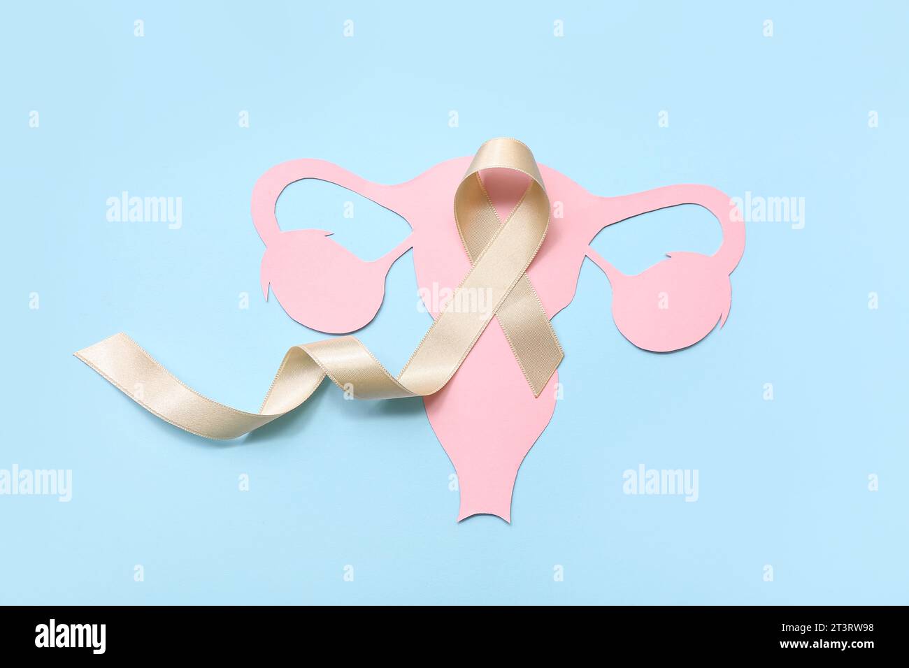 Beige ribbon with paper uterus on blue background. Cancer awareness ...