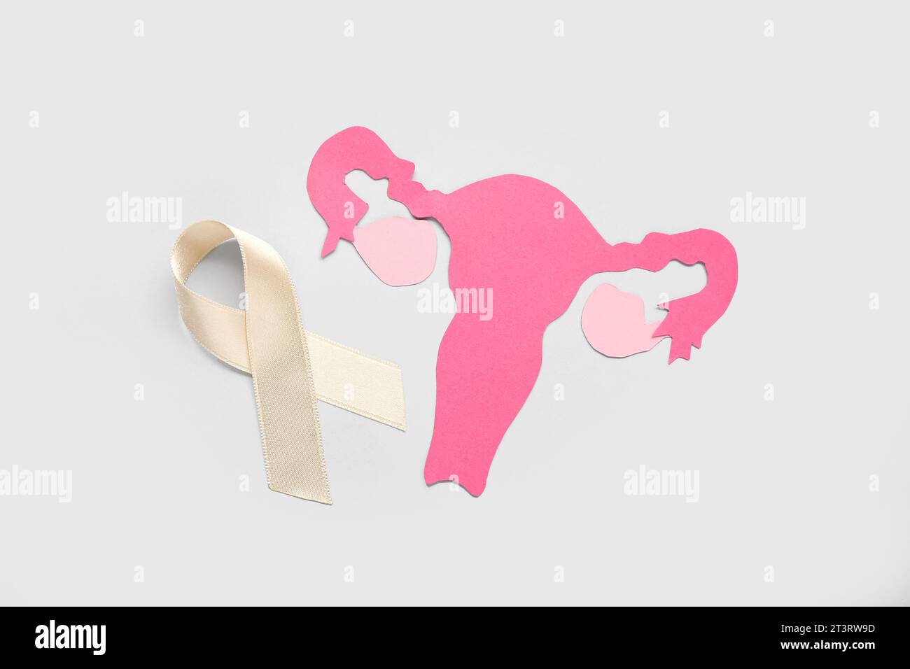 Paper uterus with beige ribbon on light background. Cancer awareness ...