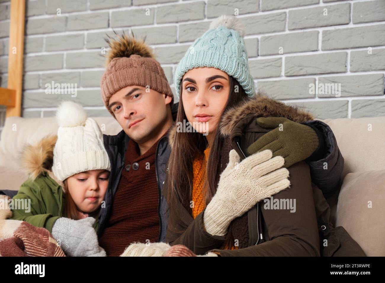 Frozen family in warm clothes at home with lack of heating Stock Photo ...