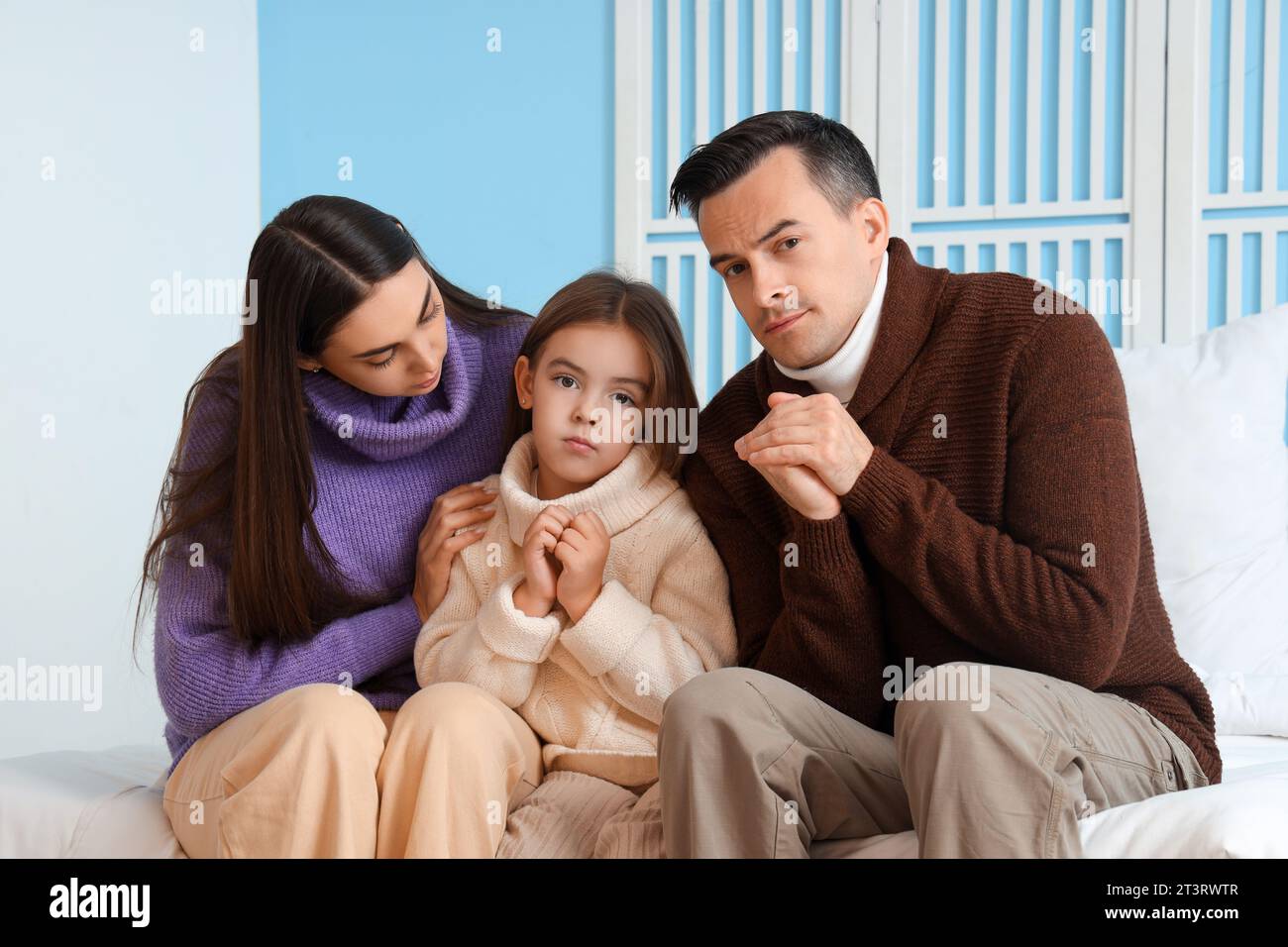 Frozen family in bedroom with lack of heating Stock Photo - Alamy