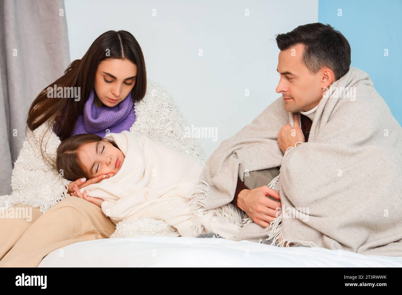 Frozen family in bedroom with lack of heating Stock Photo - Alamy