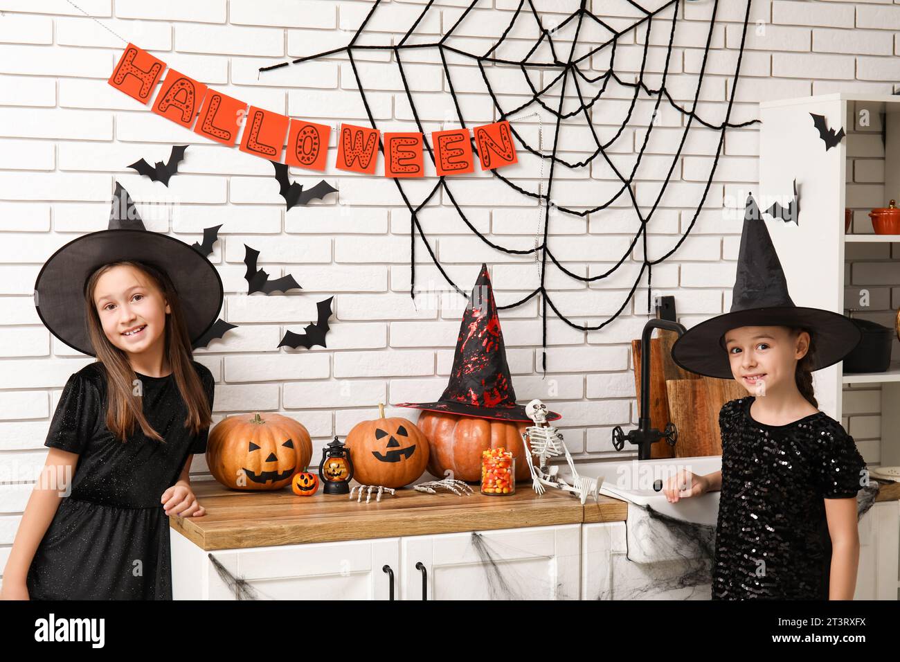 Cute little girls dressed as witches with pumpkins and candies in ...