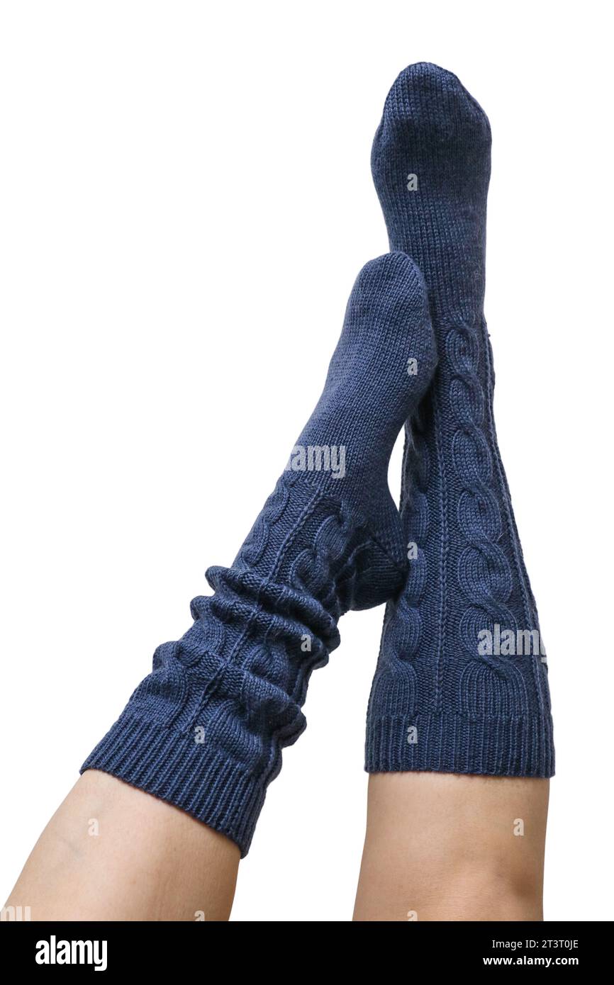 Female legs in dark blue hand knitted wool knee socks isolated on white ...