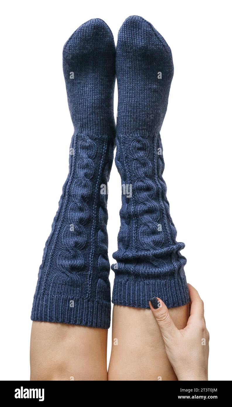 Female legs in dark blue hand knitted wool knee socks isolated on white ...