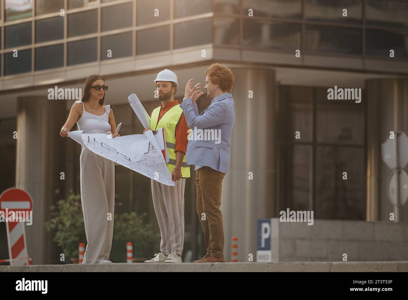 Architects and engineers discuss blueprints on a construction site ...