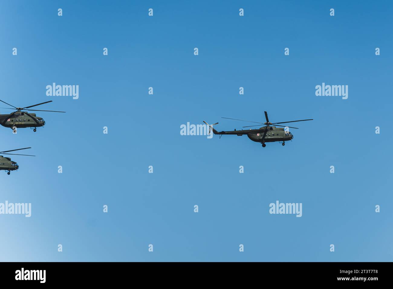 Military helicopters flying in bright blue sky performing demonstration ...
