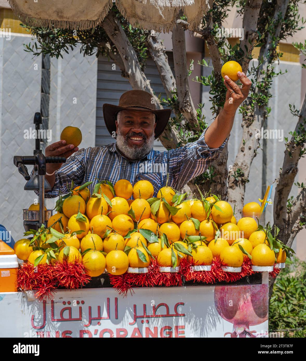 Agadir, Morocco--May 26, 2023. A merchant wearing a Fresh Squeezed ...