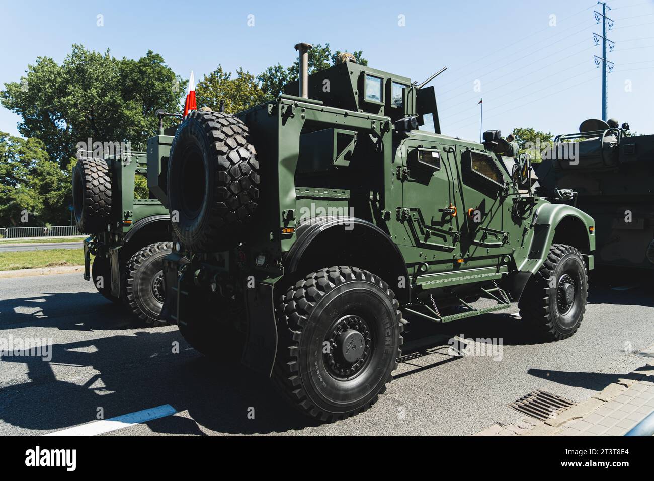Back view of massive military jeeps on a street in a convoy. Dark blue ...