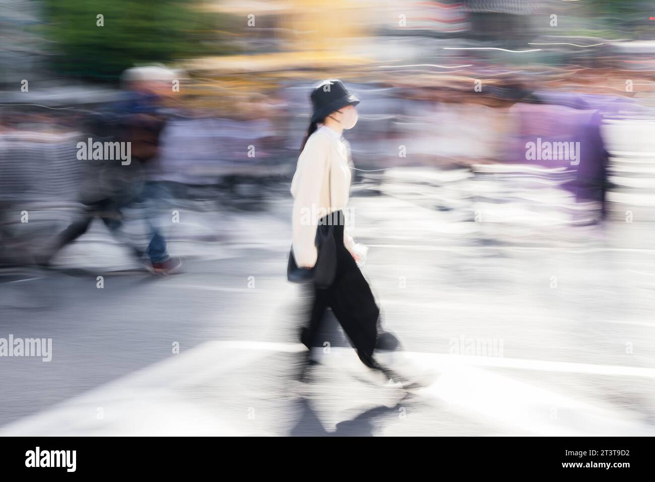 picture with motion blur effect of a Japanese woman crossing a city ...