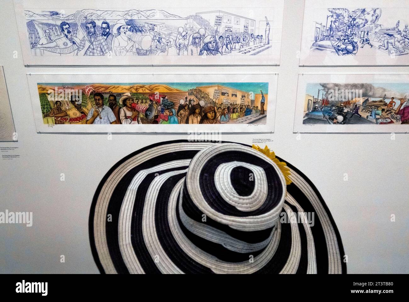 A gallery visitor looks at rough sketches of the river murals displayed ...