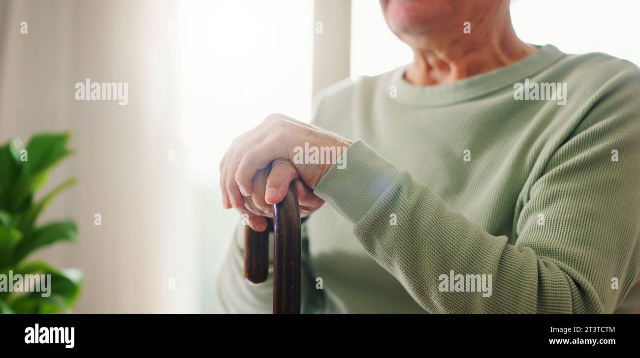 Hands, old person with disability and walking stick, closeup with ...