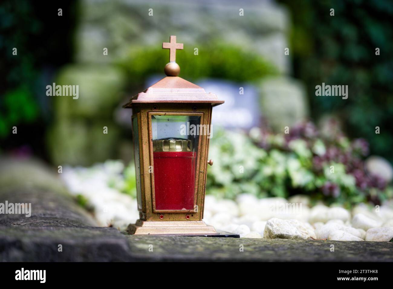 metal grave lantern with cross in front of old tombstone in blurred background Stock Photo - Alamy