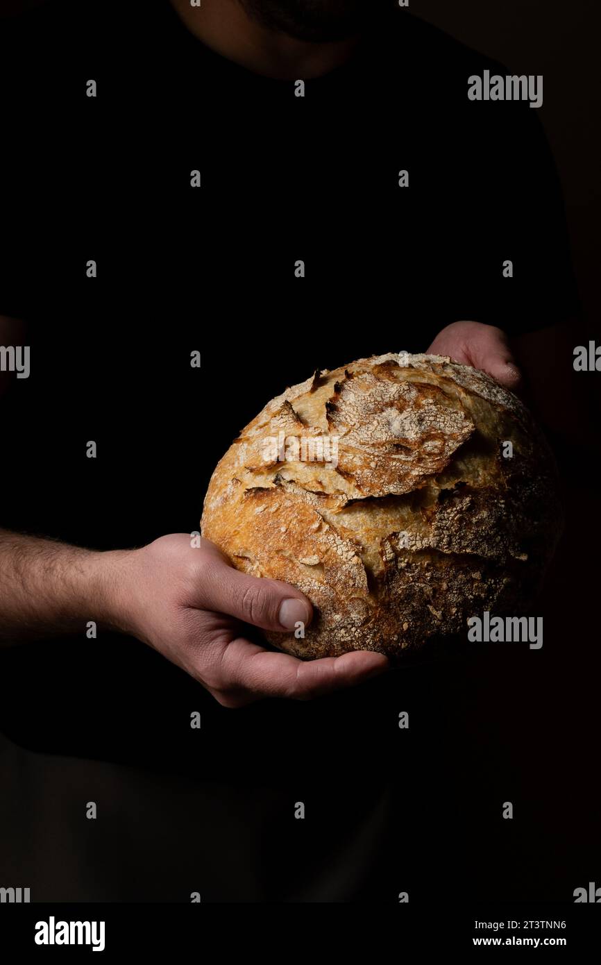 Attractive young Caucasian chef posing with white sourdough bread. The ...