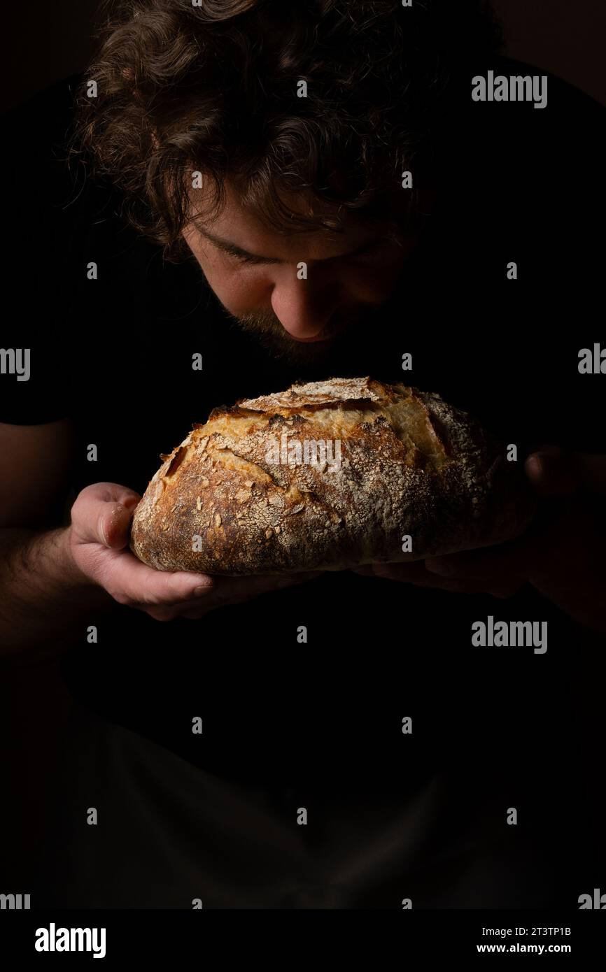 Attractive young Caucasian chef posing with white sourdough bread. The ...