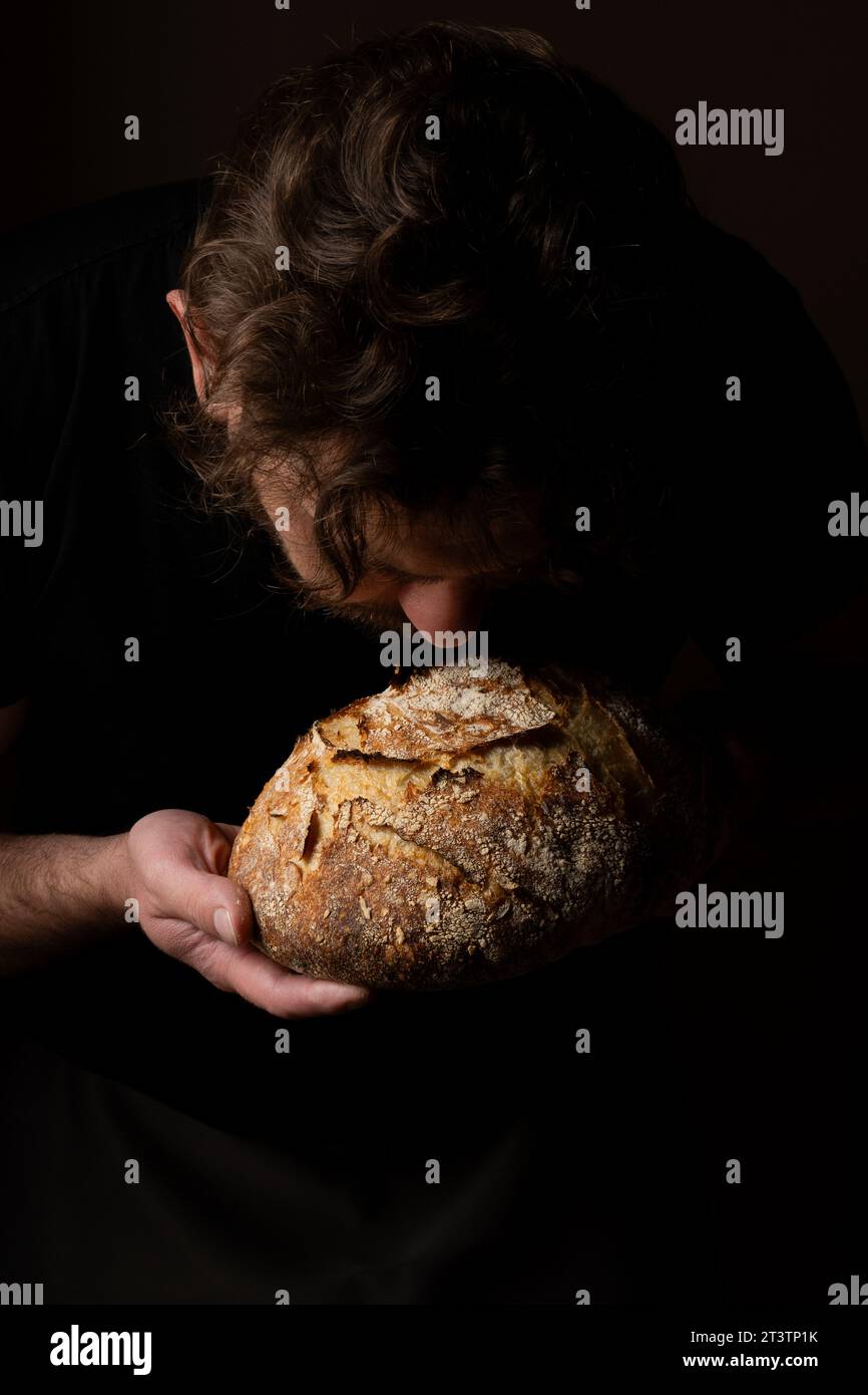 Attractive young Caucasian chef posing with white sourdough bread. The ...