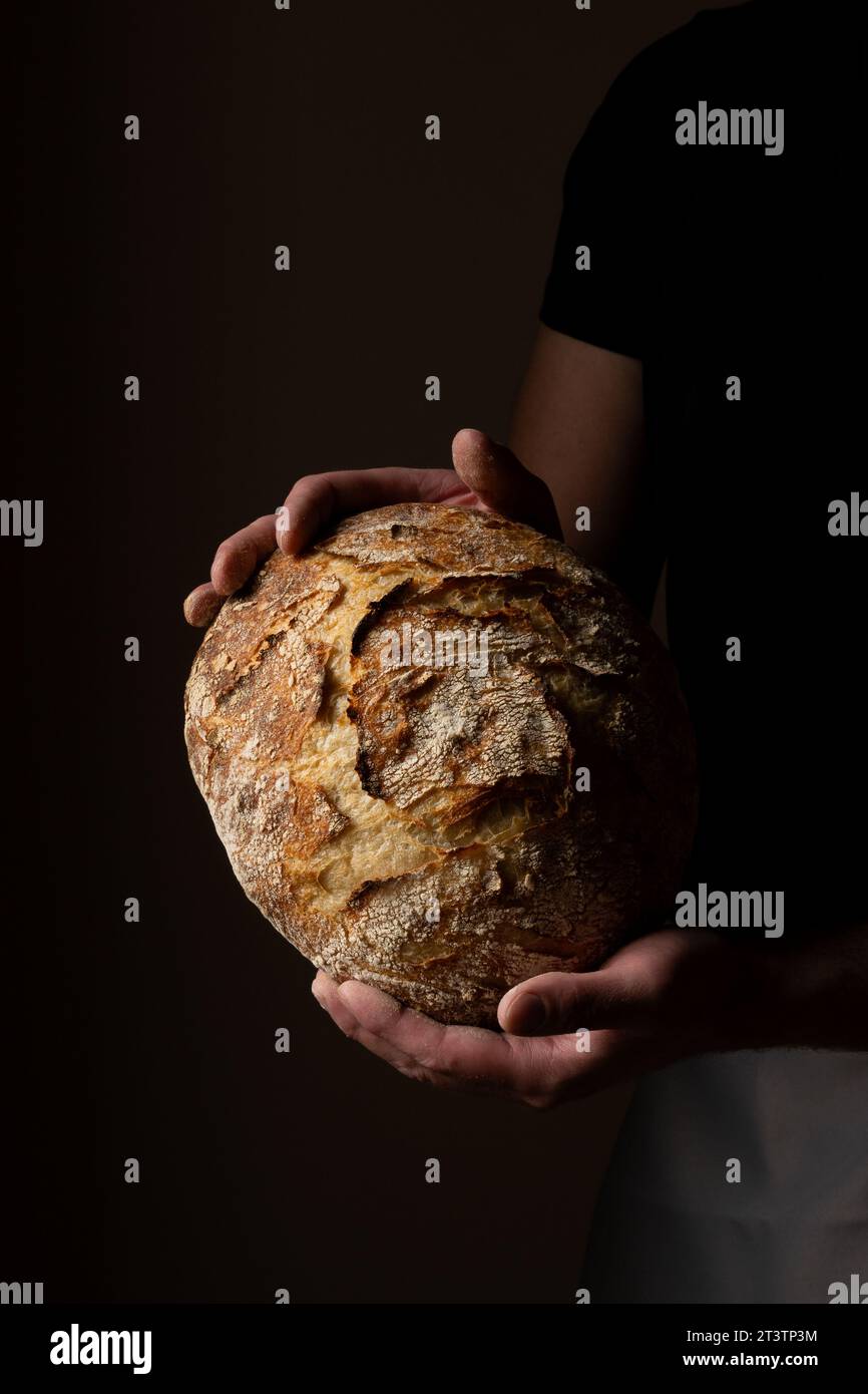 Attractive young Caucasian chef posing with white sourdough bread. The ...