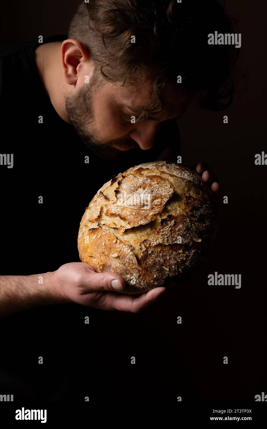 Attractive young Caucasian chef posing with white sourdough bread. The ...