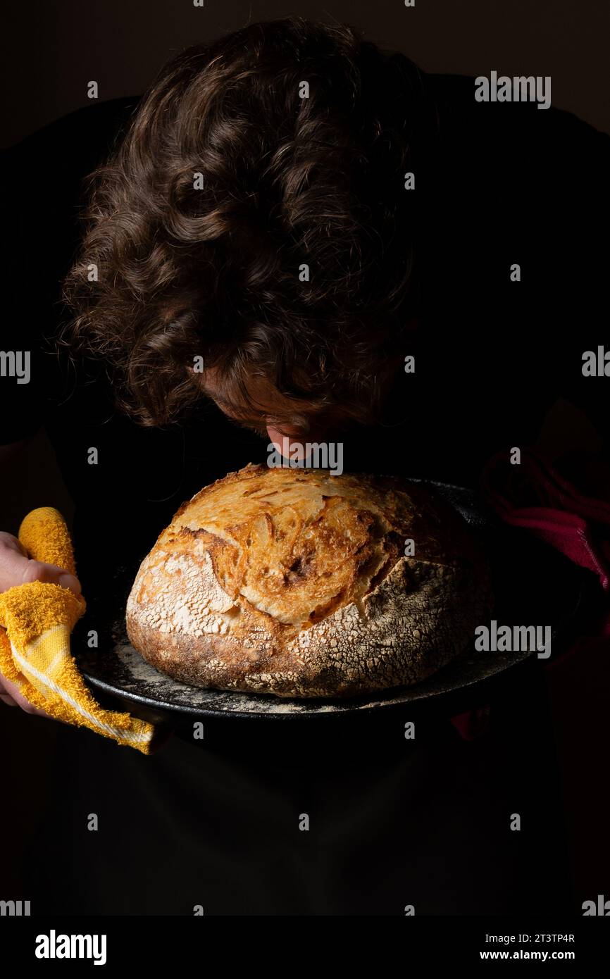 Attractive young Caucasian chef posing with white sourdough bread. The ...