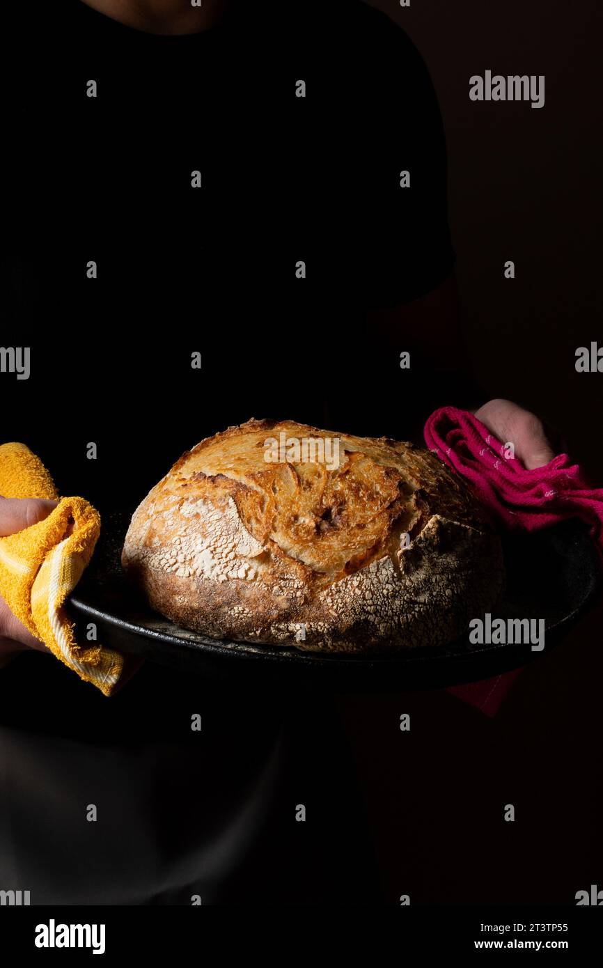 Attractive young Caucasian chef posing with white sourdough bread. The ...