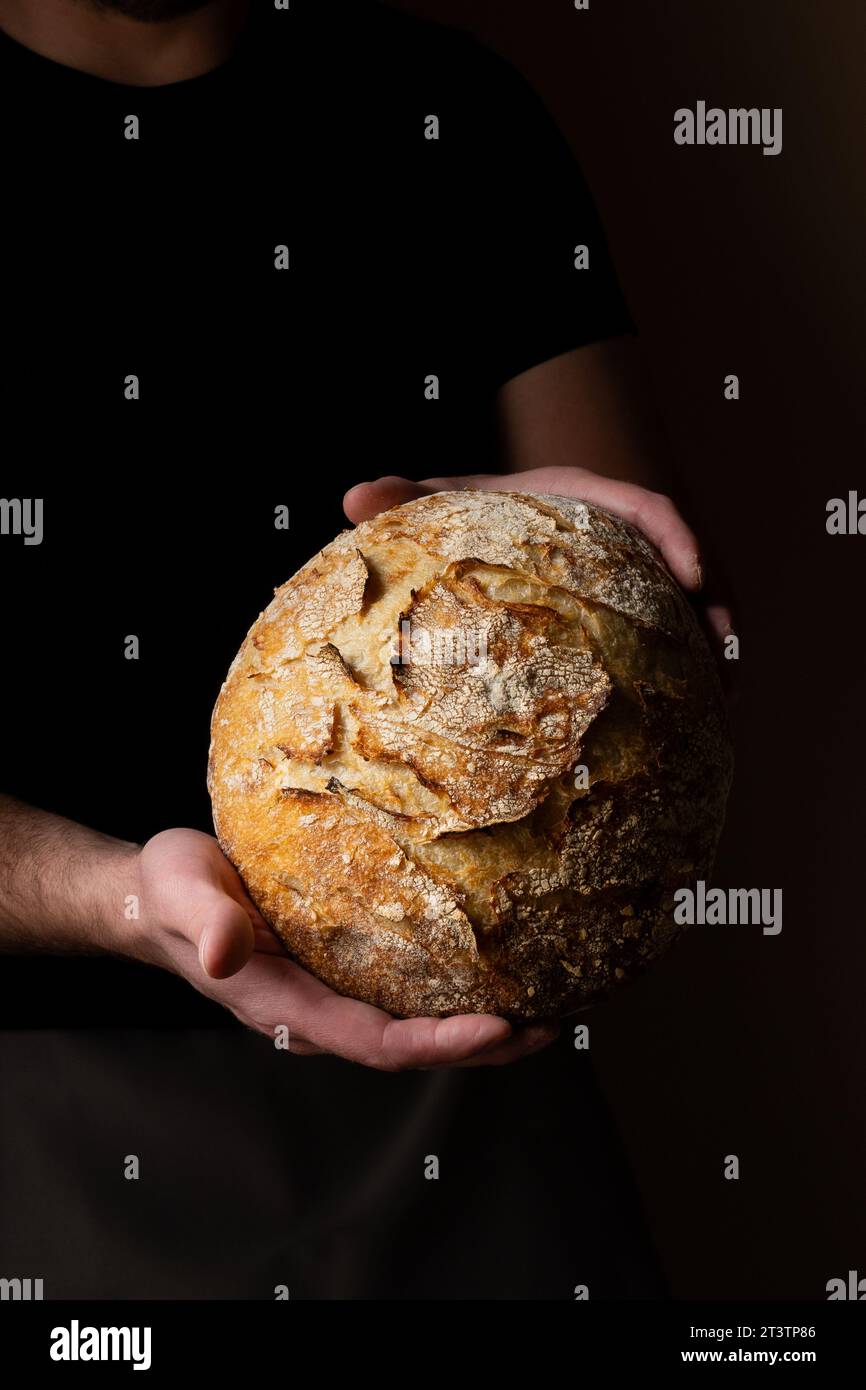 Attractive young Caucasian chef posing with white sourdough bread. The ...