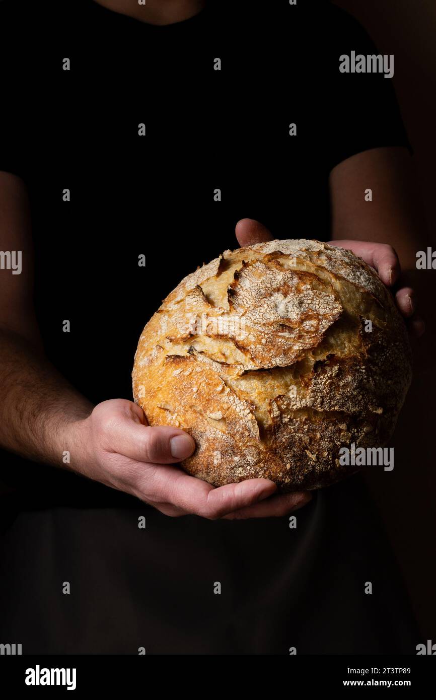Attractive young Caucasian chef posing with white sourdough bread. The ...
