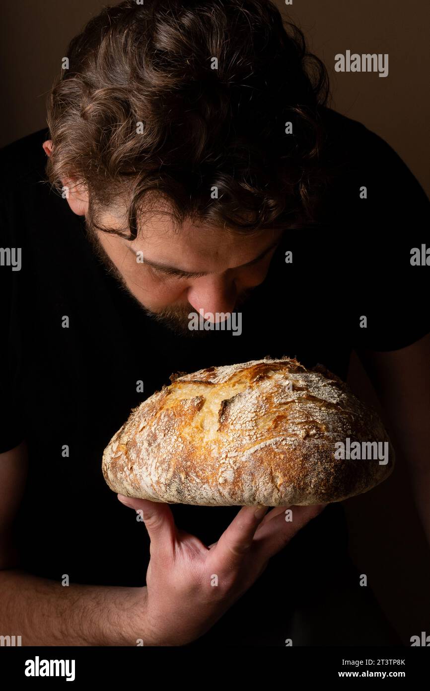 Attractive young Caucasian chef posing with white sourdough bread. The ...