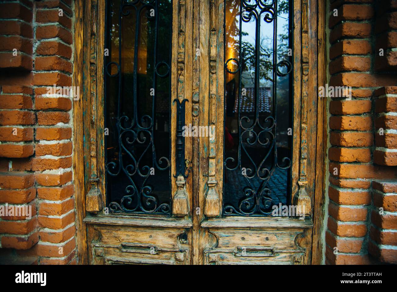 Close up of a heavy wooden plant double door, with iron hinges and ...