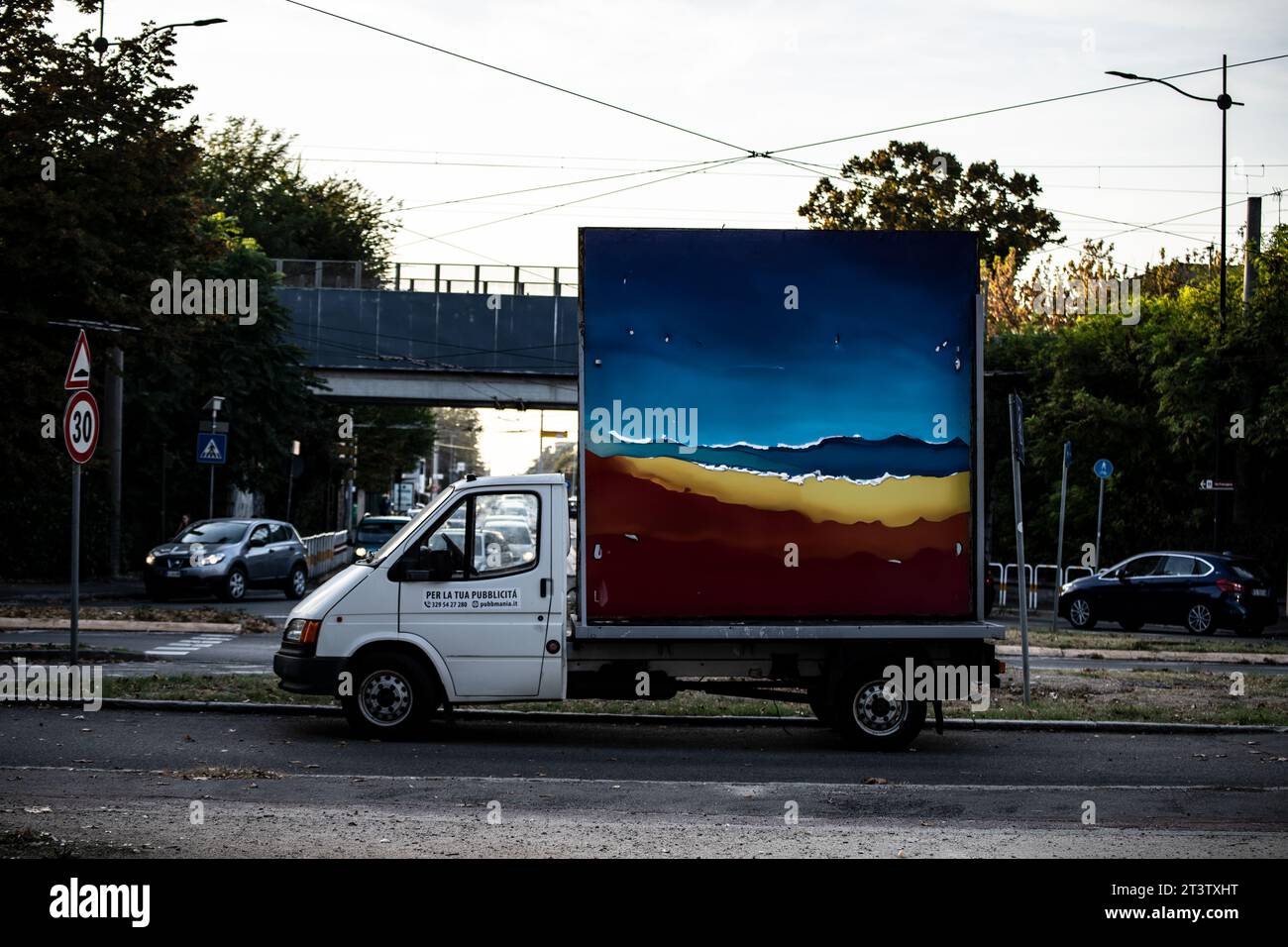 An imposing billboard adorns a traveling van, its vibrant display ...