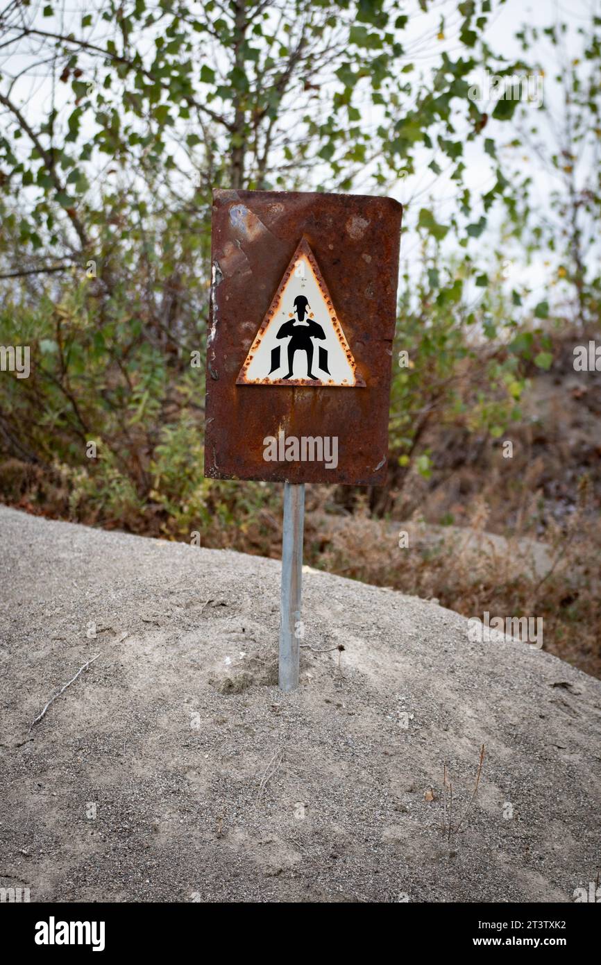 Warning signs with poles planted in the sand near a chemical plant in ...