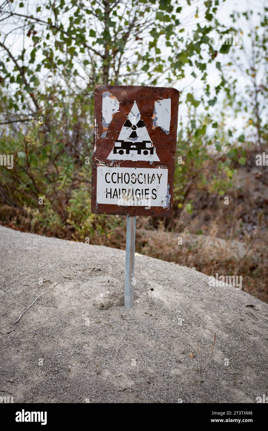 Warning signs with poles planted in the sand near a chemical plant in ...