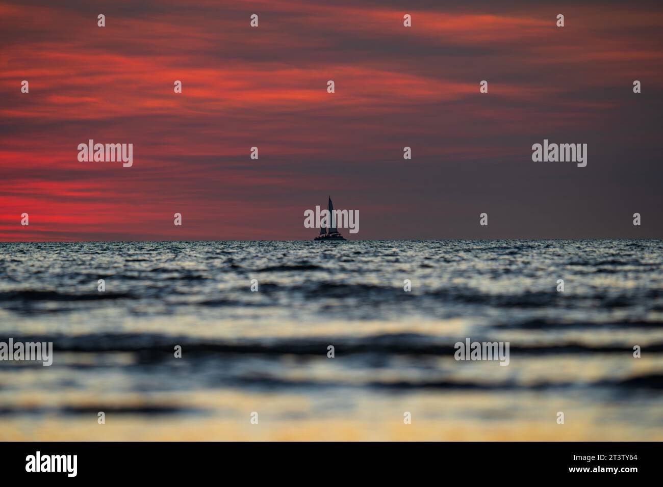 Sailing boat at sunset Stock Photo - Alamy
