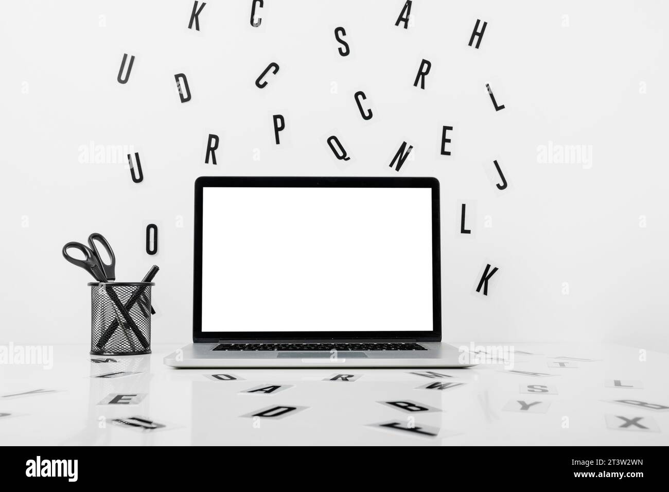 Laptop with blank white screen near pencil holder alphabets white ...