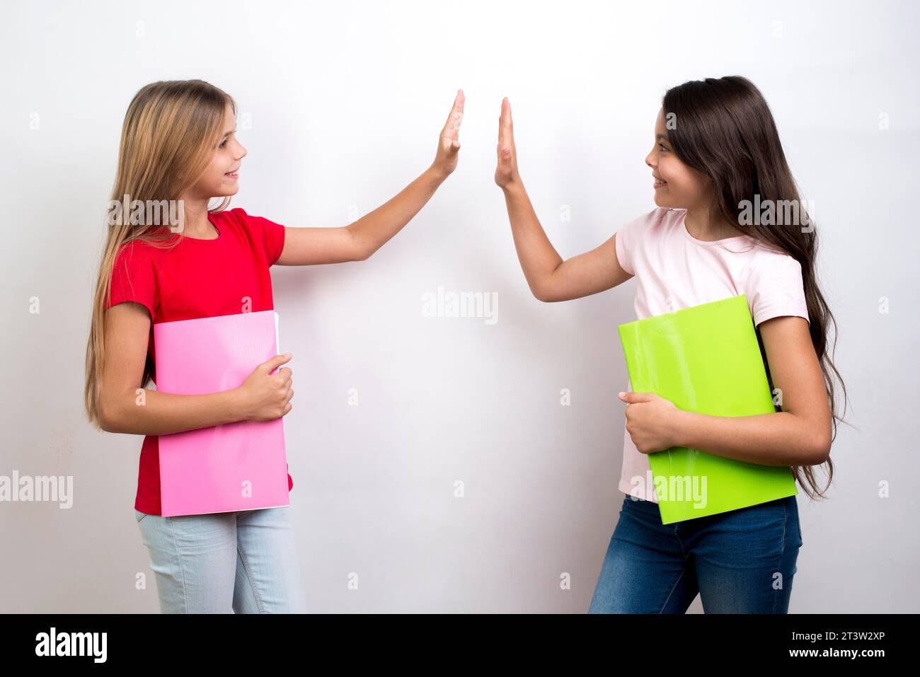 Multiethnic schoolgirls giving high five Stock Photo - Alamy