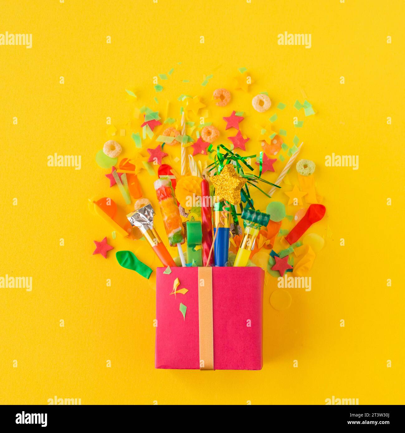 Open gift box with candies party accessories yellow background Stock ...