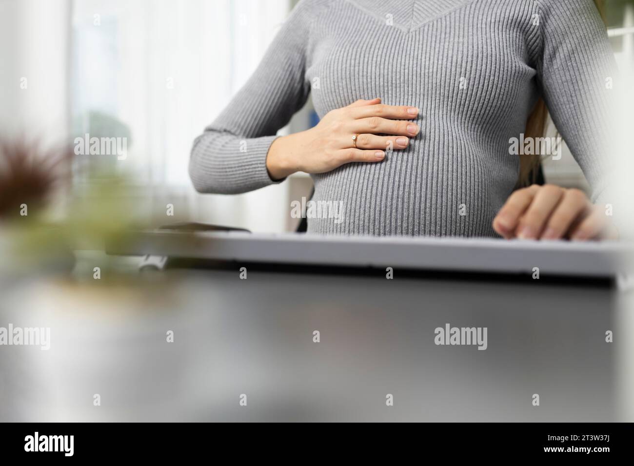 Pregnant businesswoman office desk holding her belly Stock Photo - Alamy
