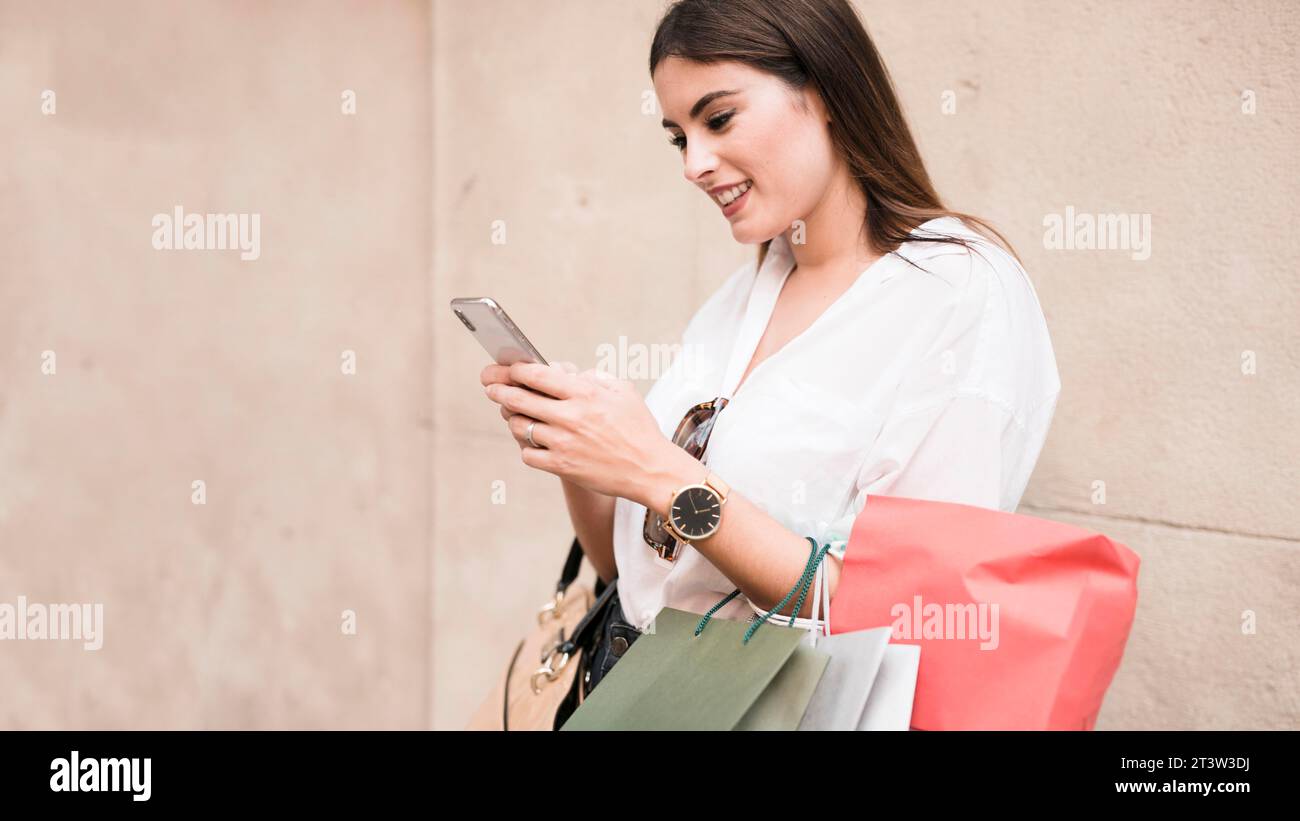 Shopping girl using her mobile phone Stock Photo - Alamy