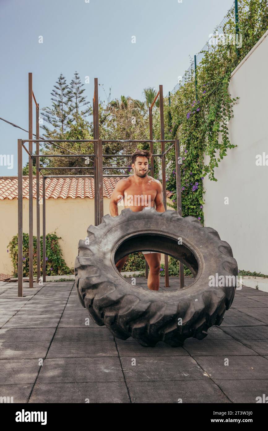 Sporty man lifting wheel Stock Photo - Alamy