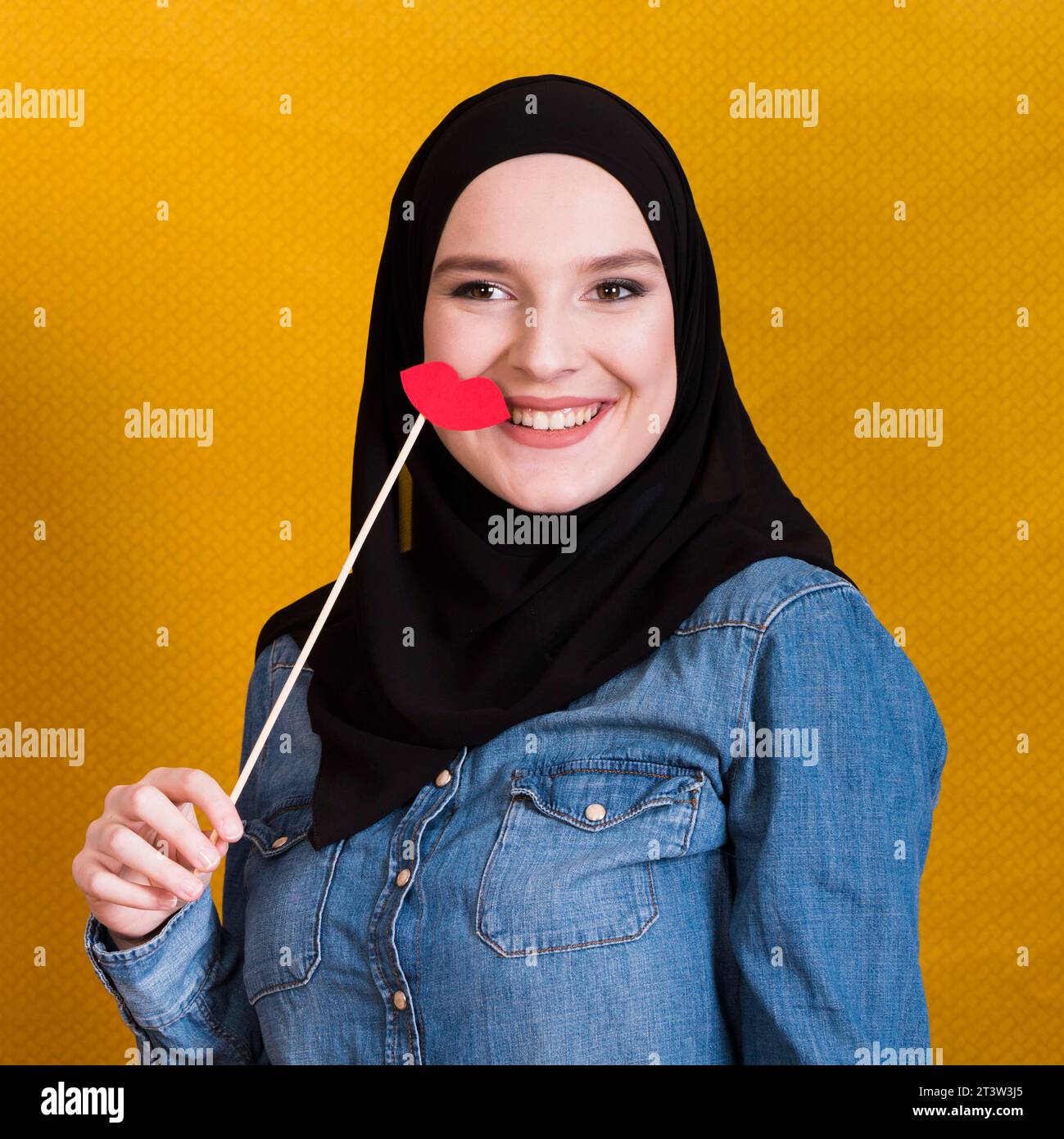 Smiling muslim woman holding paper prop shape red lips backdrop Stock ...