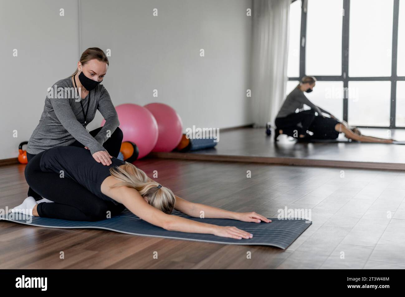 Workout with personal trainer stretching back Stock Photo - Alamy