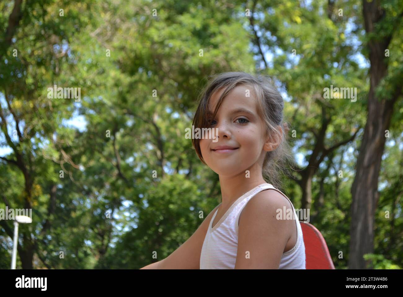 Cute kid girl 10 year old posing on nature background. Looking at ...