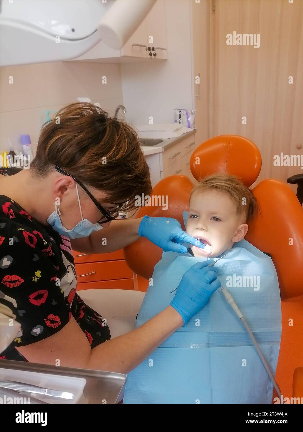 Female dentist examines the teeth of the patient cheerful child with ...