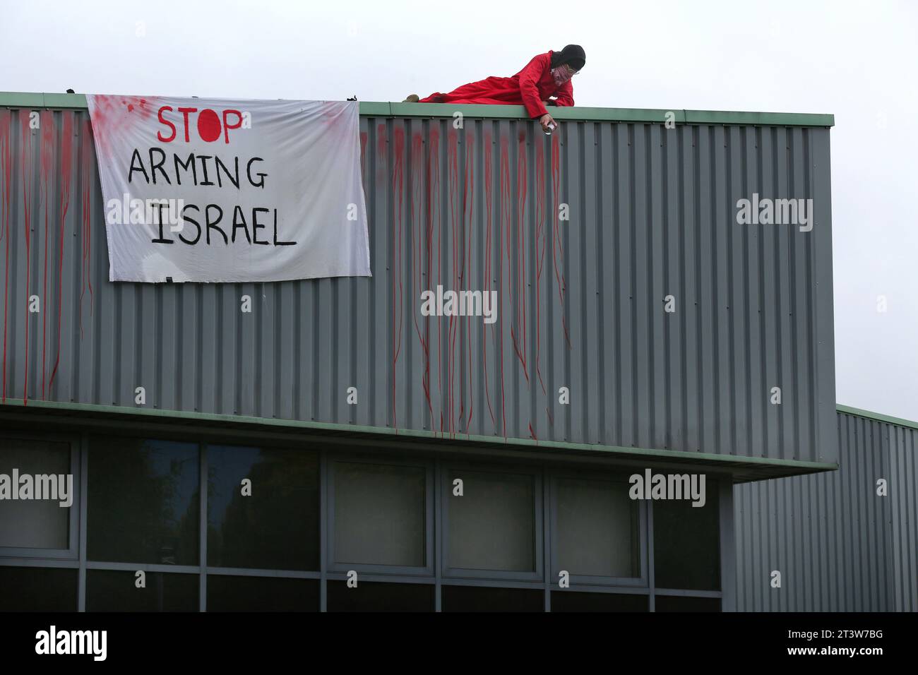 An activist from Palestine Action sprays the building with red paint to ...