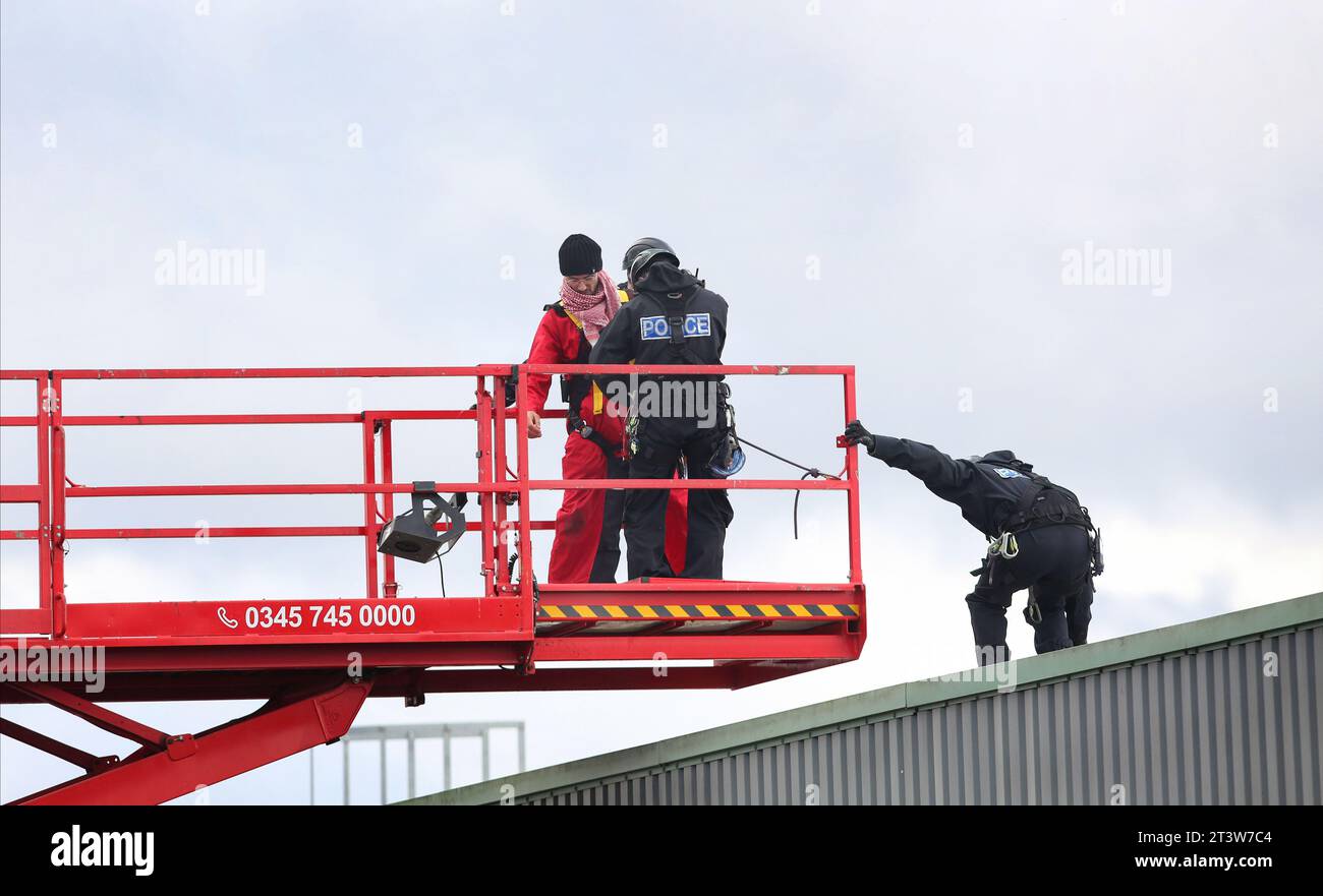 Police officers use a scissor lift to get on the roof to arrest two ...
