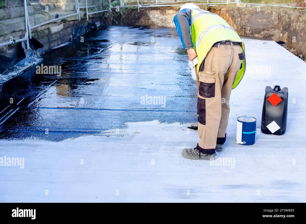 Waterproofing coating. Builder applying waterproofing bitumen mastic on ...