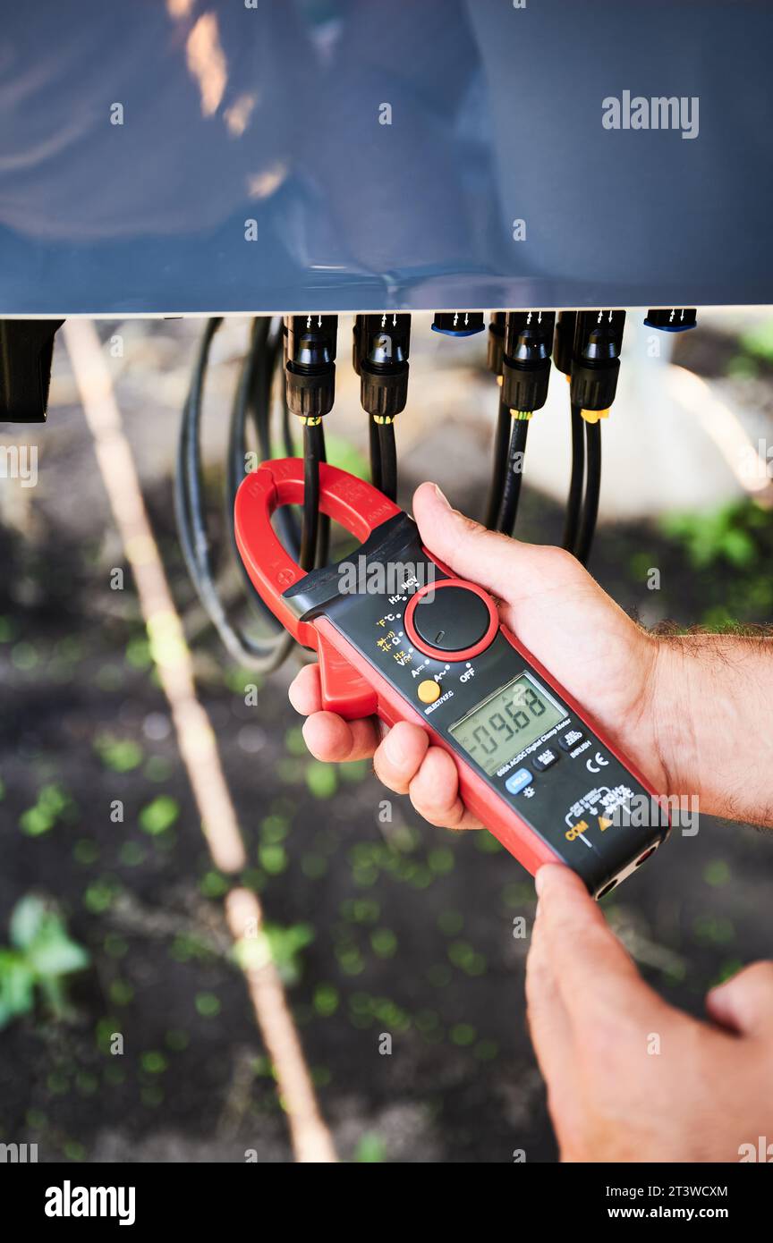 Checking of output voltage level of inverter. Professional worker using ...