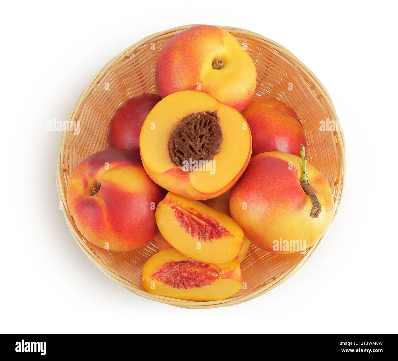 Ripe nectarine fruit with half in a wicker basket isolated on white ...