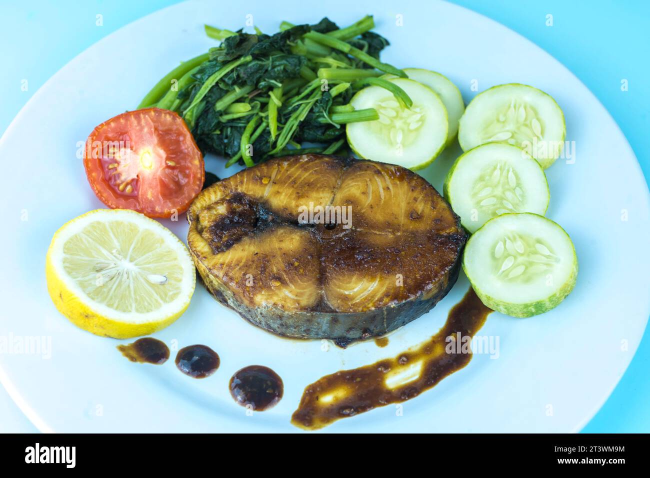 Grilled king fisher fish on a plate, with crispy skin and flaky white ...