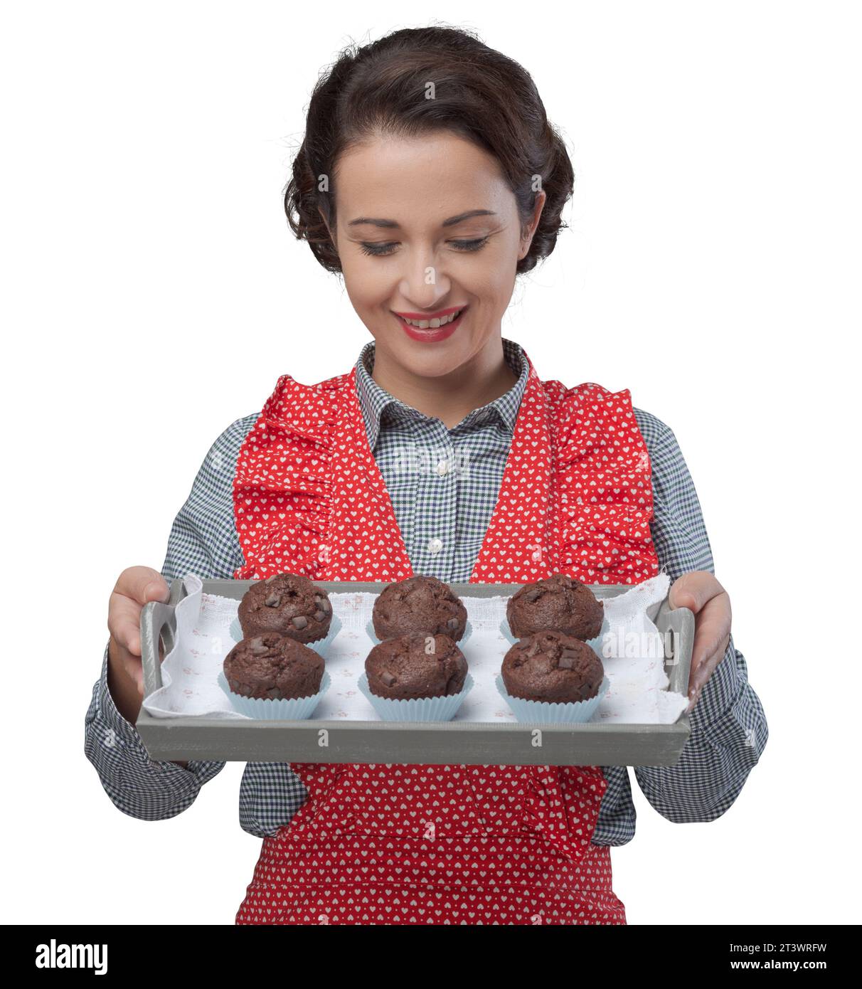 Smiling vintage woman in apron serving homemade chocolate muffins on a ...
