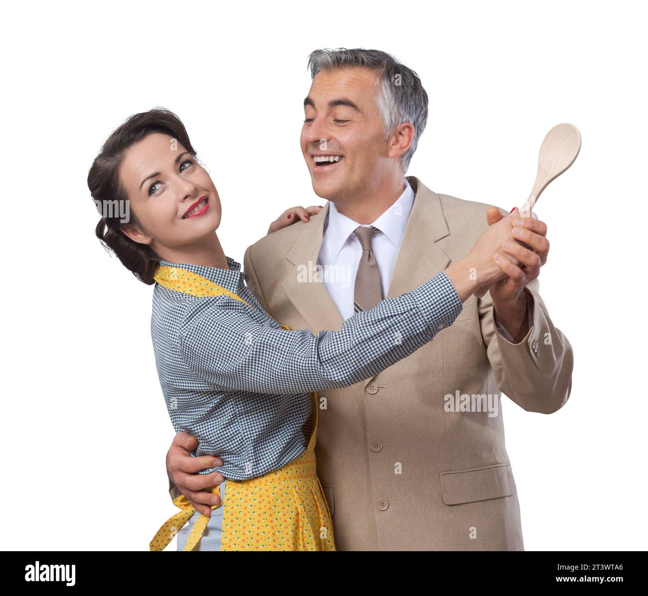 Smiling vintage couple dancing in the kitchen and holding a wooden ...
