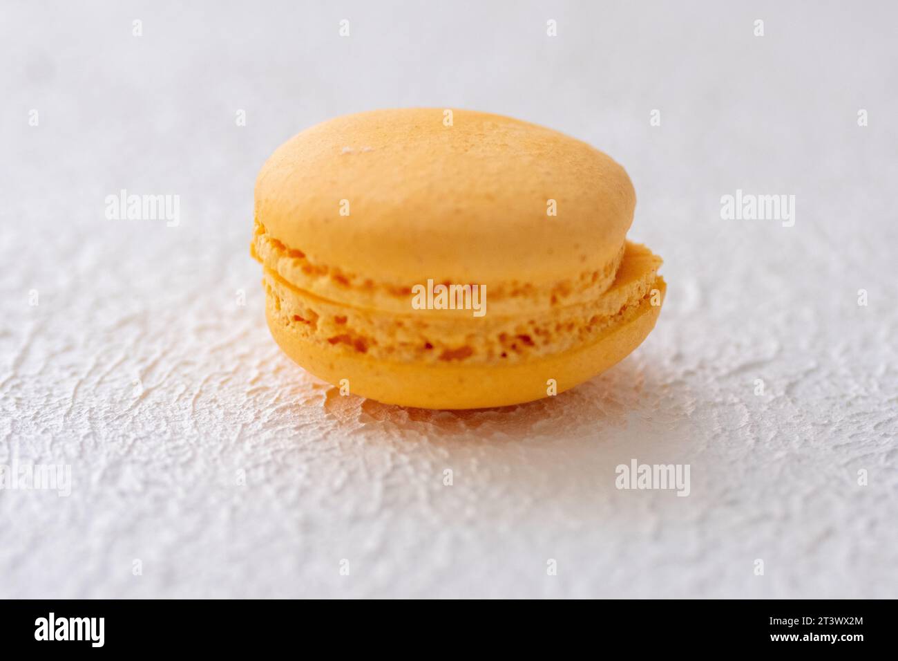 orange macaroon on white background in close-up Stock Photo - Alamy